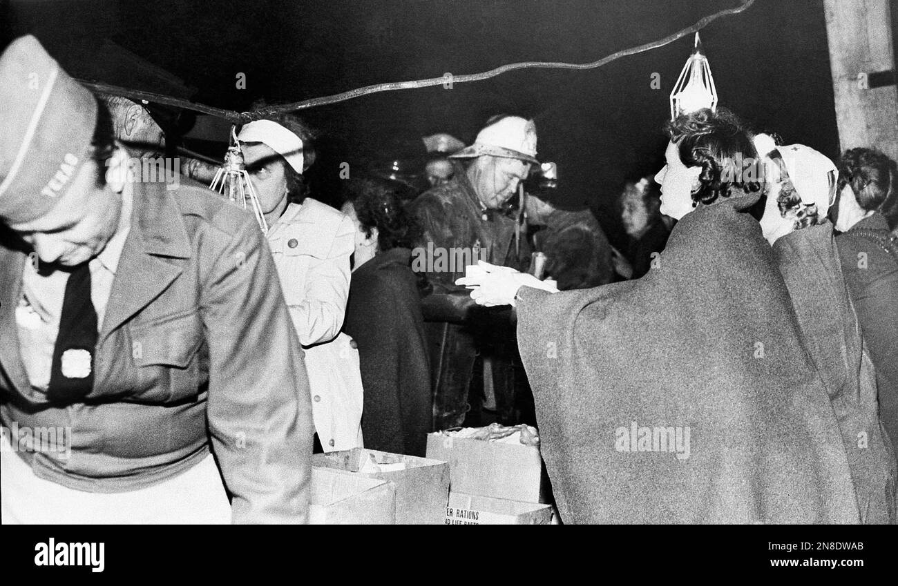 Weary rescue and relief workers receive sandwiches and warm drinks from ...