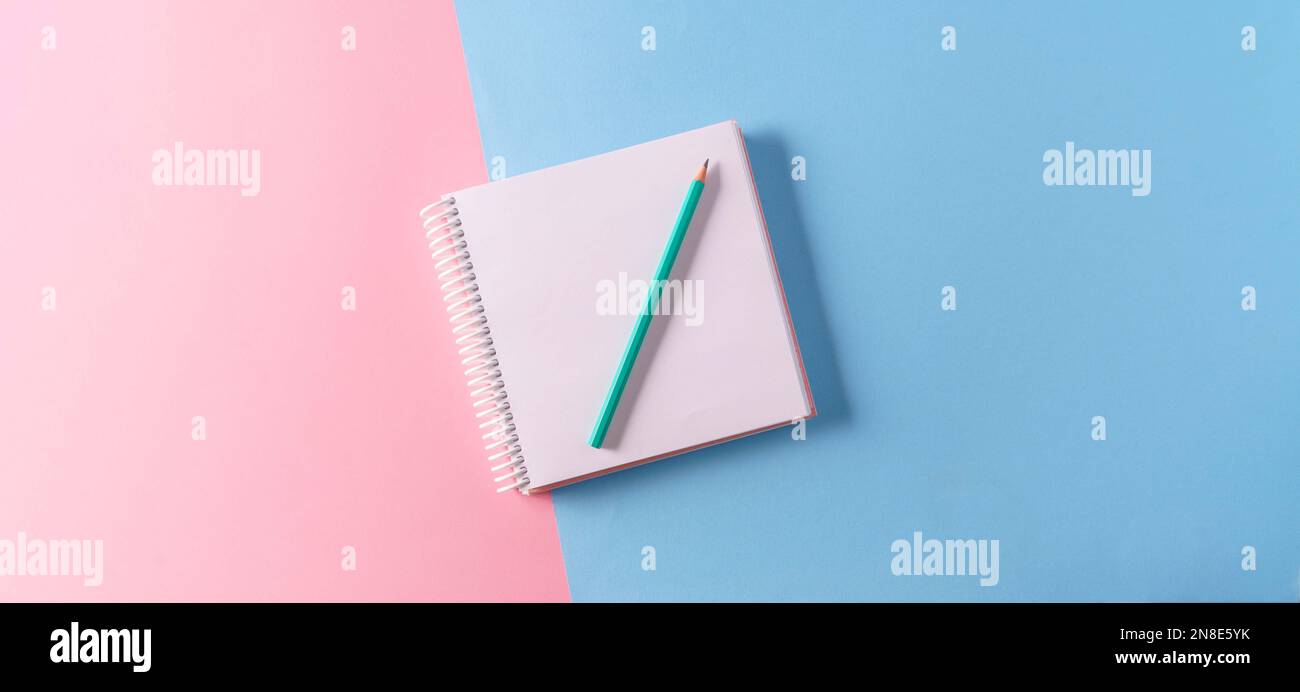 Mockup. An empty A4 notebook on blue and pink paper background, top ...