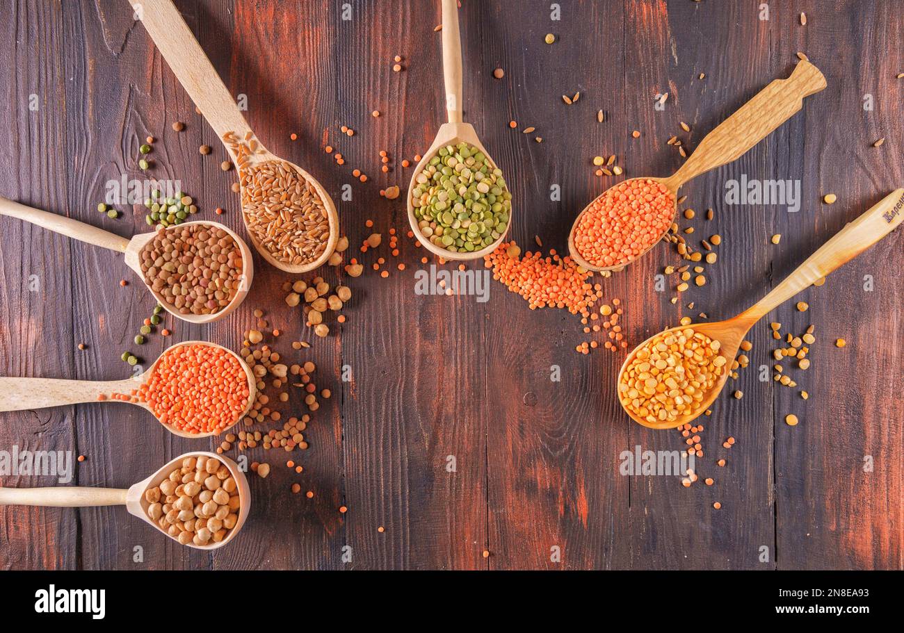Spoons with peas,lentils and beans on wooden background, top view,flat ...