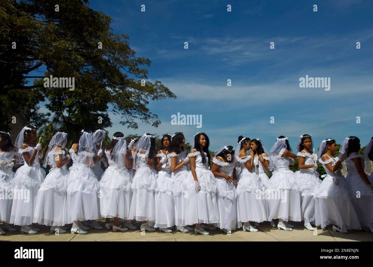 Girls wearing their communion dresses form a line to enter a banquet ...