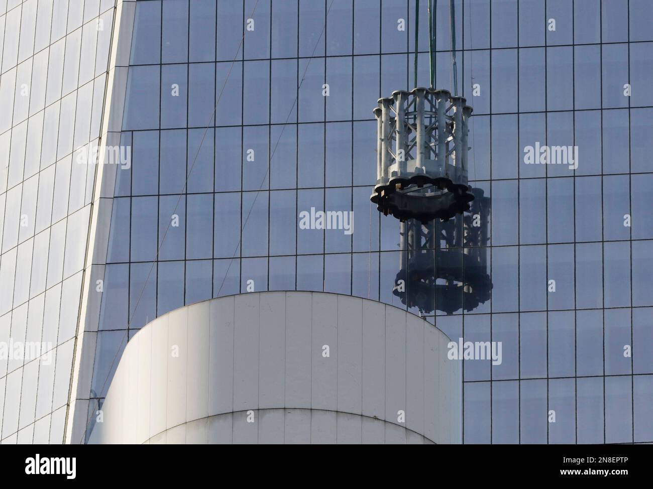 The first section of a 408-foot spire is hoisted by crane to the top of ...