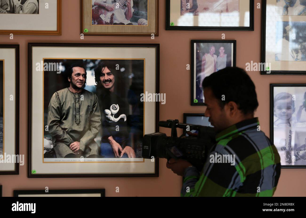 An Indian cameraman films a photograph of the Beatles' George Harrison ...
