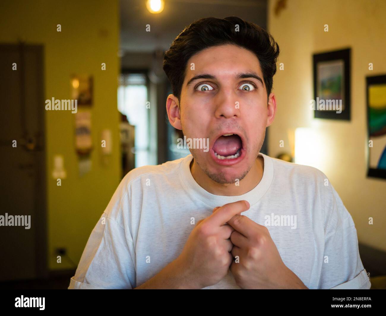 Scared young man screaming, frightened at home Stock Photo - Alamy