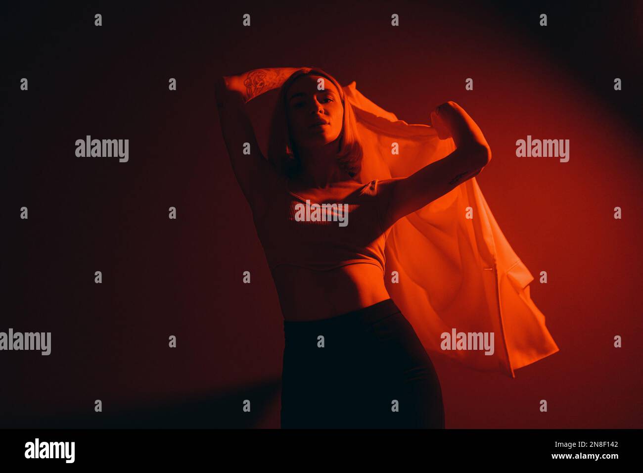 Female with jacket in raised arms in studio Stock Photo - Alamy
