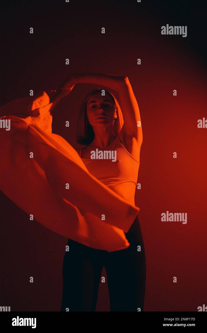 Female with jacket in raised arms in studio Stock Photo - Alamy