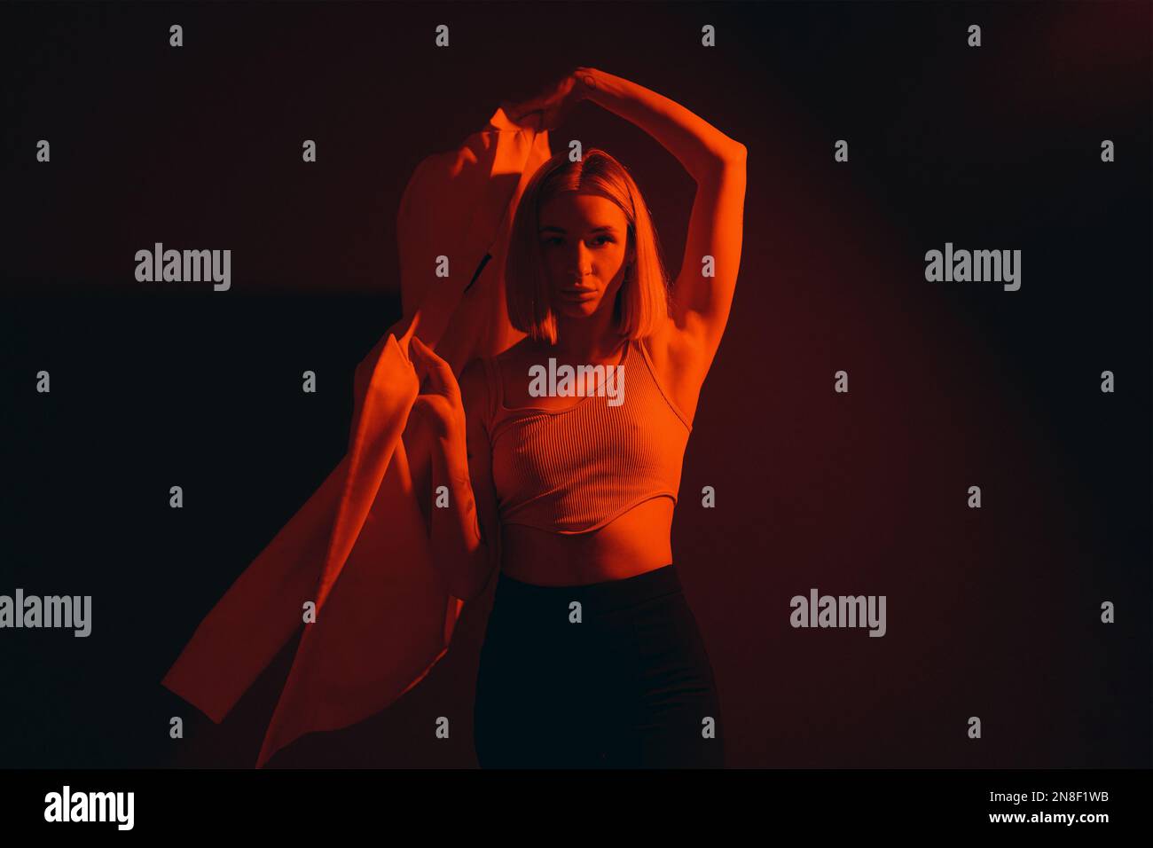 Female with jacket in raised arms in studio Stock Photo - Alamy