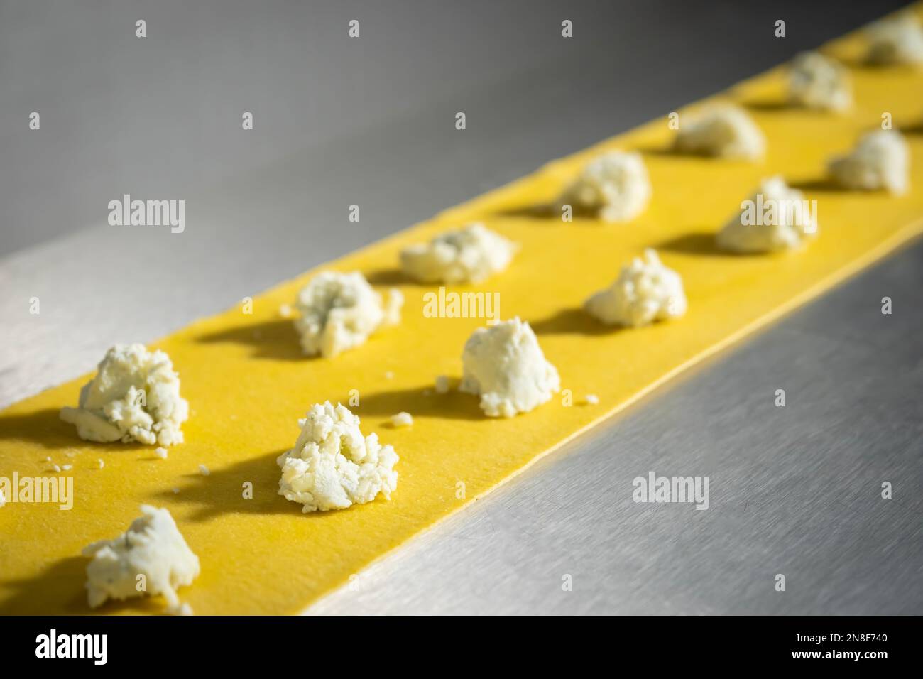 Preparing fresh made ravioli with ricotta cheese inside pasta factory ...