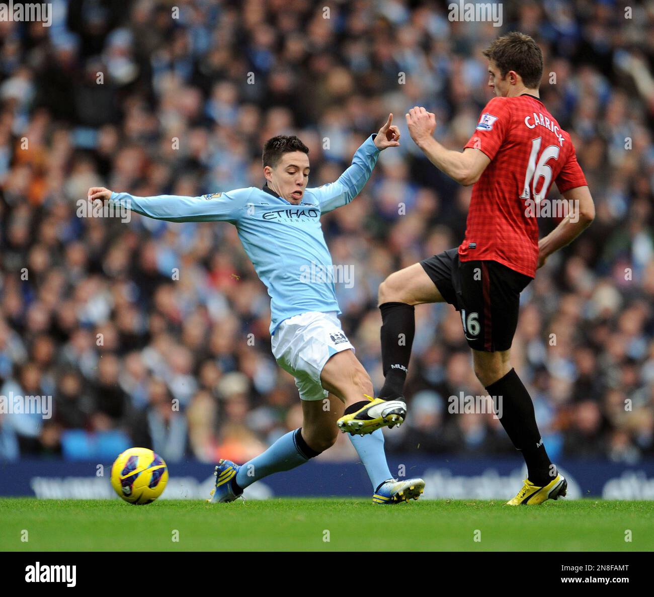 Manchester City's Samir Nasri, left is tackled by Manchester United's ...