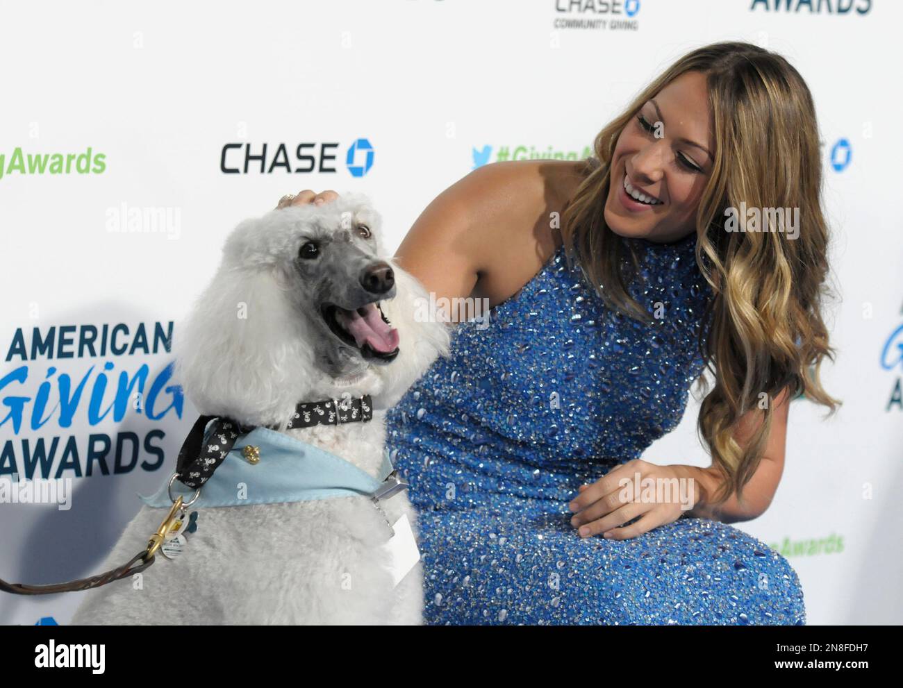 Singer Colbie Caillat reaches down to pet a poodle at The American ...