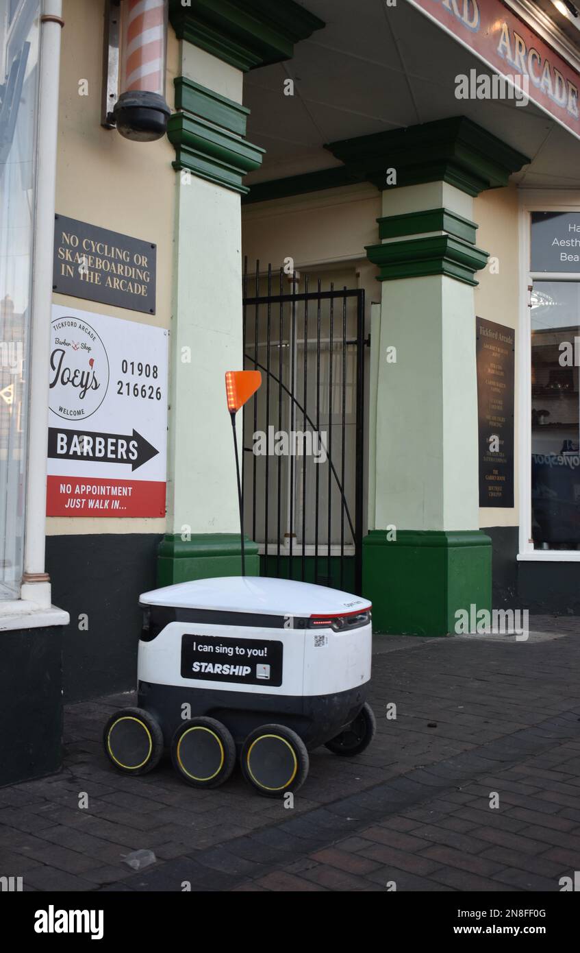 A Starship delivery robot outside a barber's shop in Newport Pagnell ...