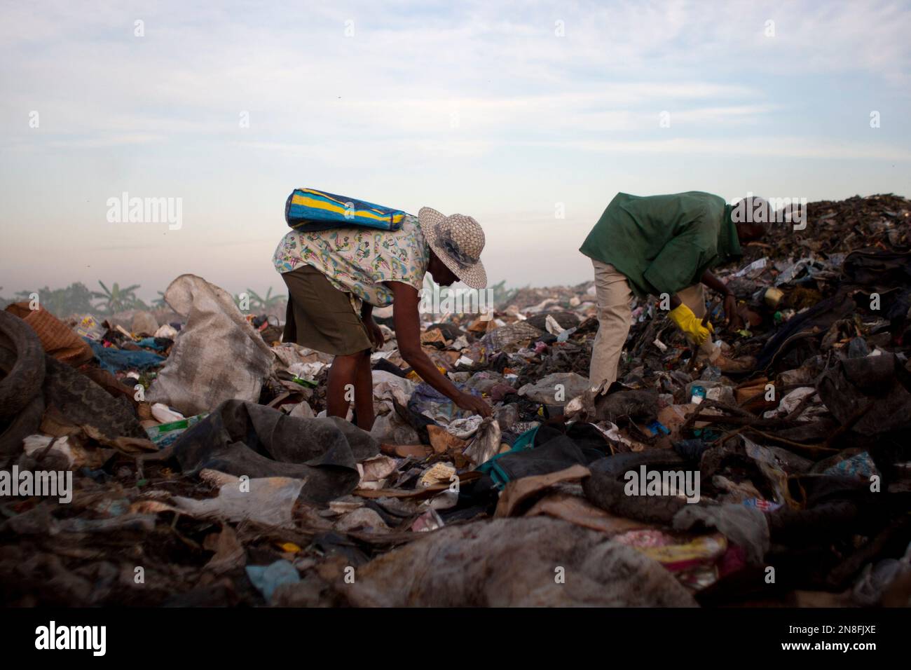A couple culls through garbage, searching for recyclable items at a ...