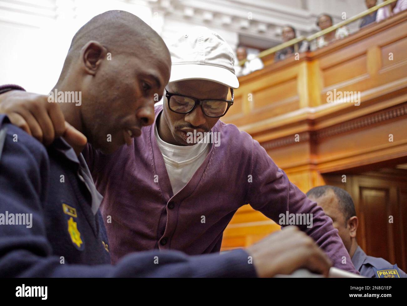 Xolile Mngeni, center, arrives in court before being sentenced at Cape ...