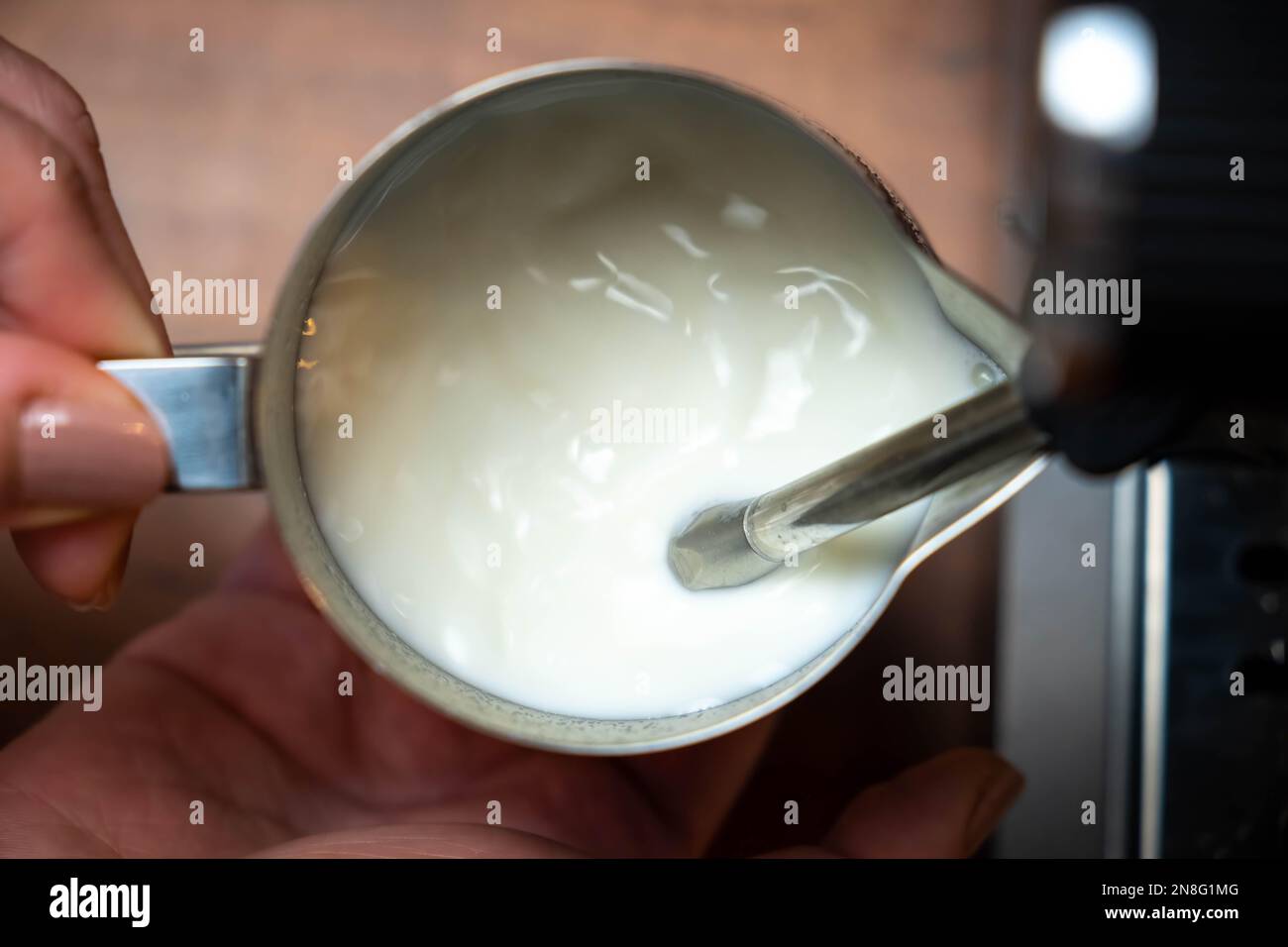 A barista froths or steams the milk to achieve a microfoam texture ...