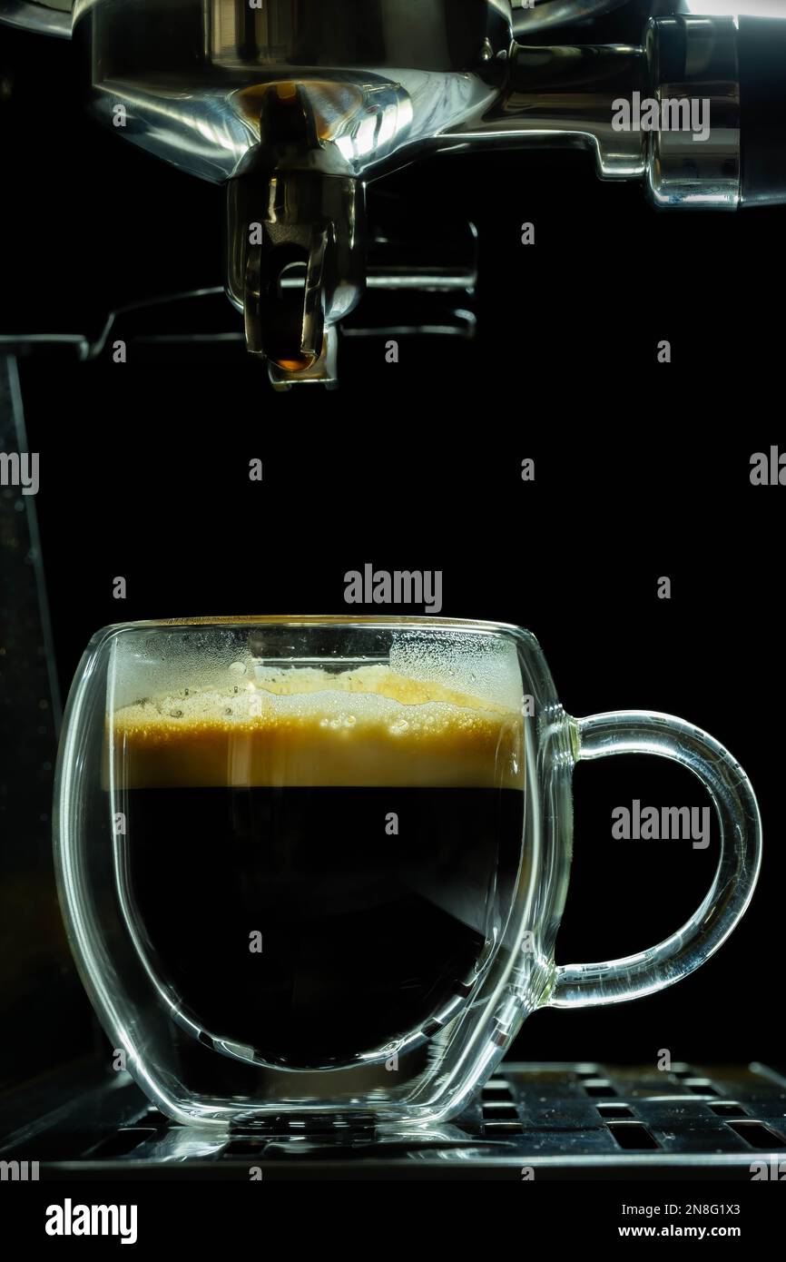 Closeup of a double espresso shot in a clear cup, still under the ...