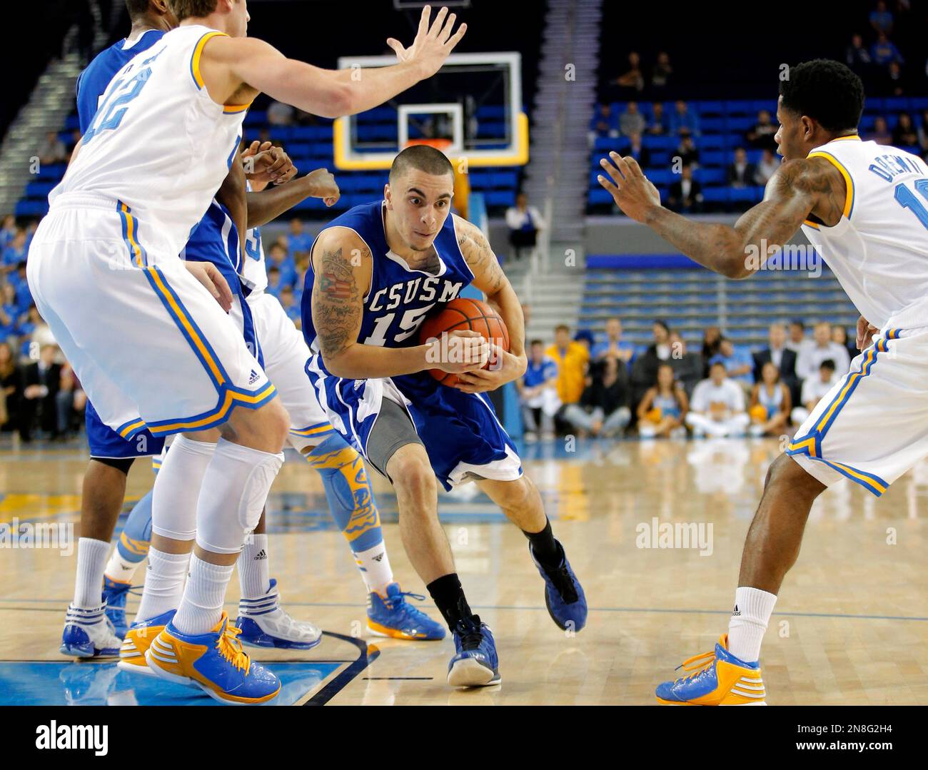 Cal State San Marcos' Jose Rivera, center, is defended by UCLA 's David ...