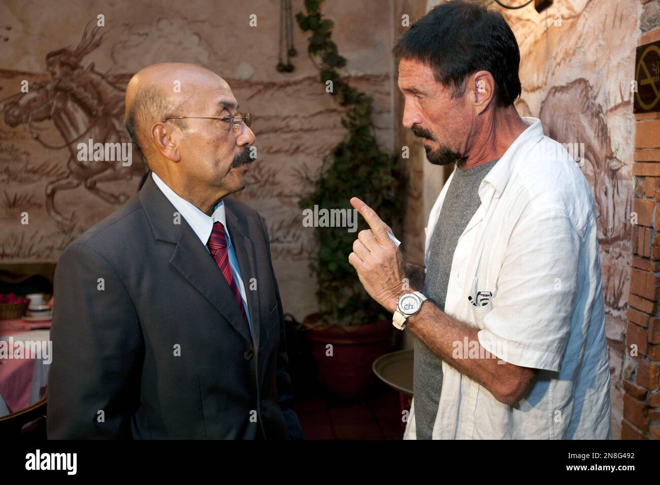 Software company founder John McAfee talks to his lawyer Telesforo Guerra, right, after giving ...
