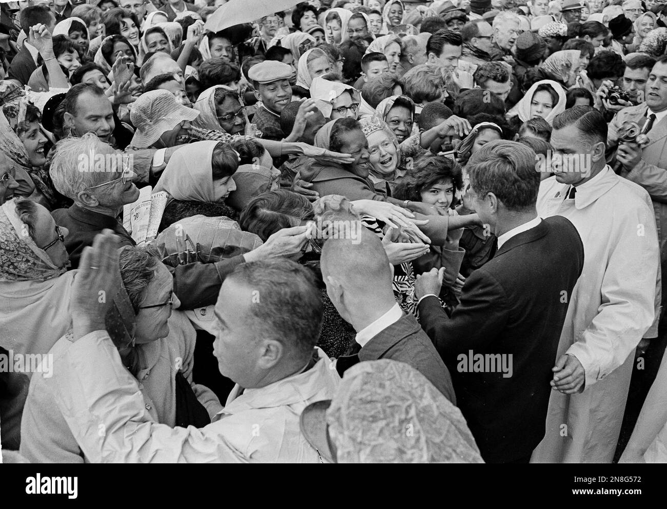 President John F. Kennedy is greeted by an enthusiastic crowd in front ...