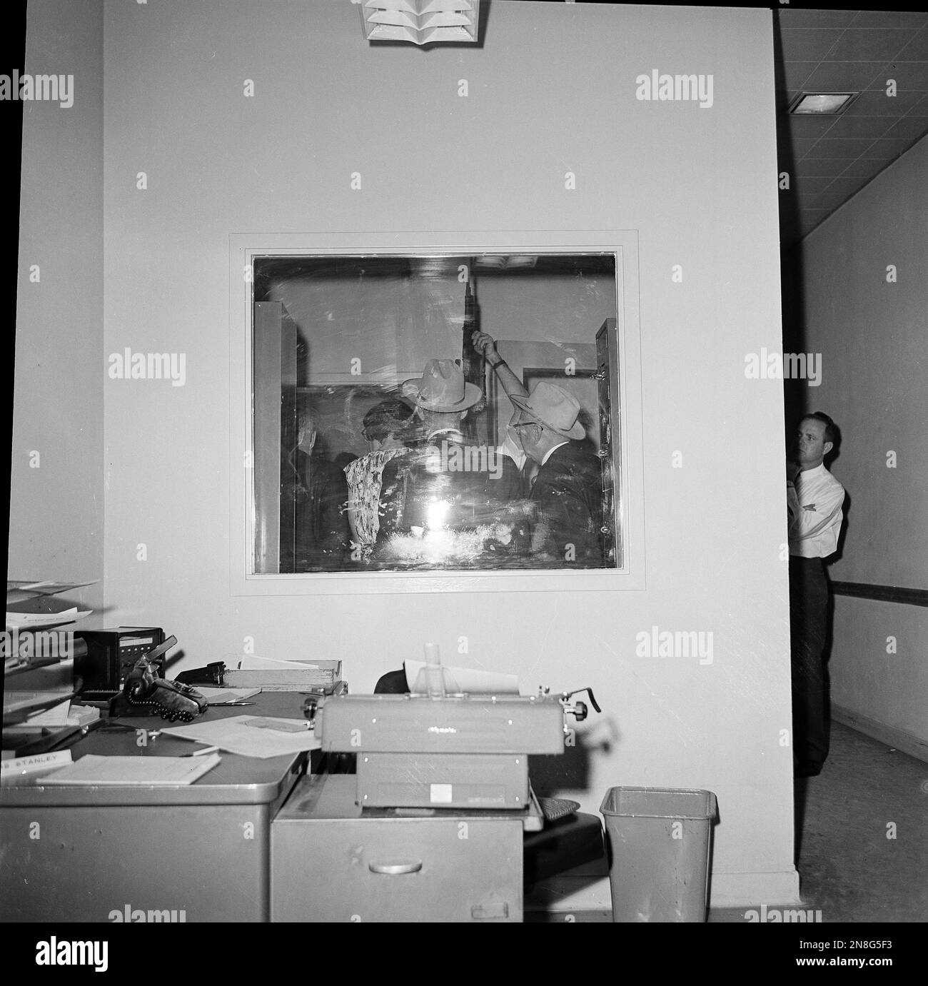 Dallas detectives hold up the rifle used in the assassination of ...