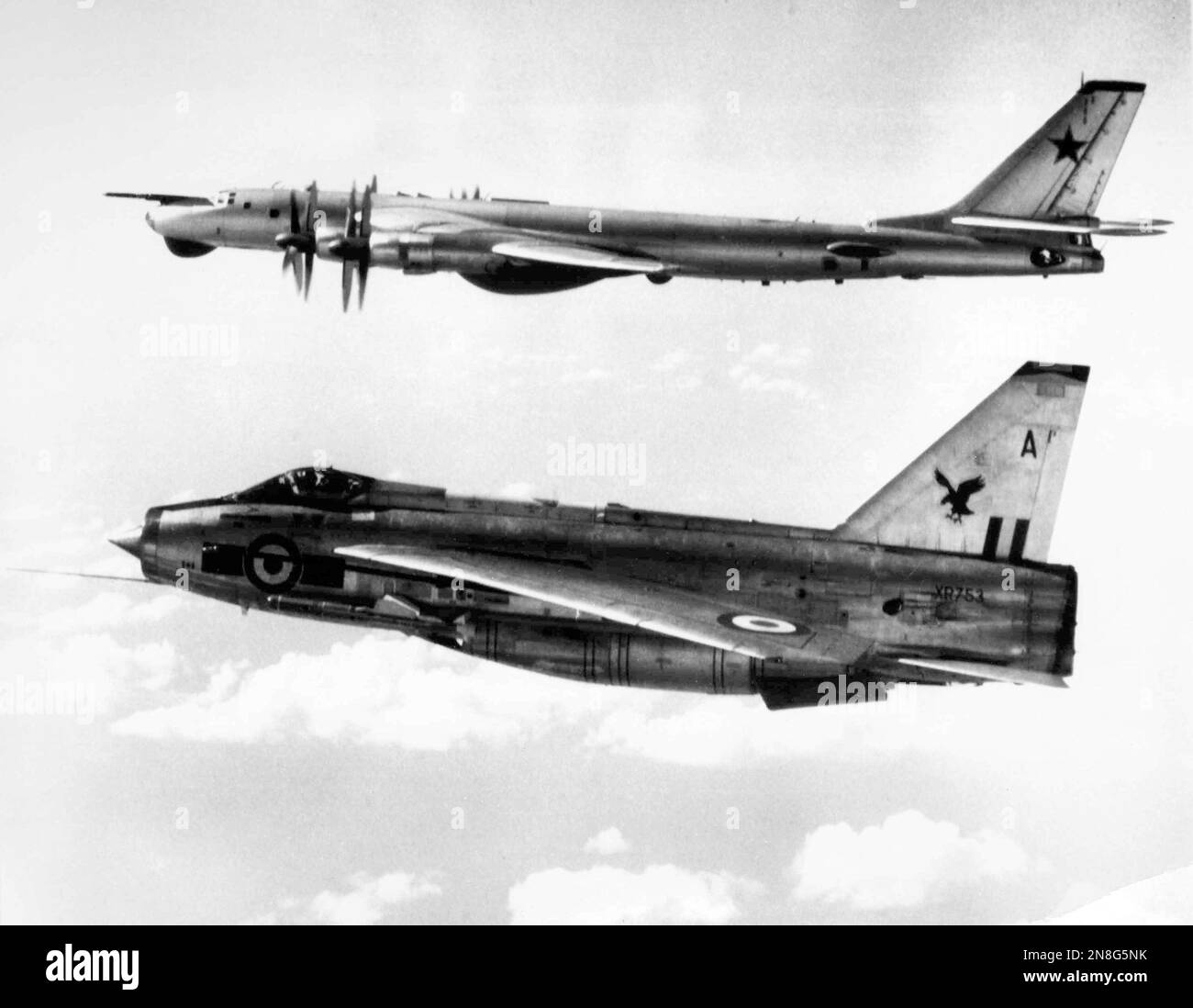 A British Royal Air Force Lightning fighter, front, flies alongside a ...