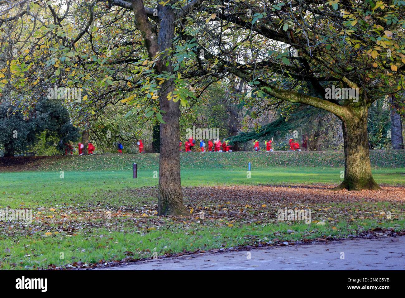 Nursery children in single file with red clothing follow teachers ...