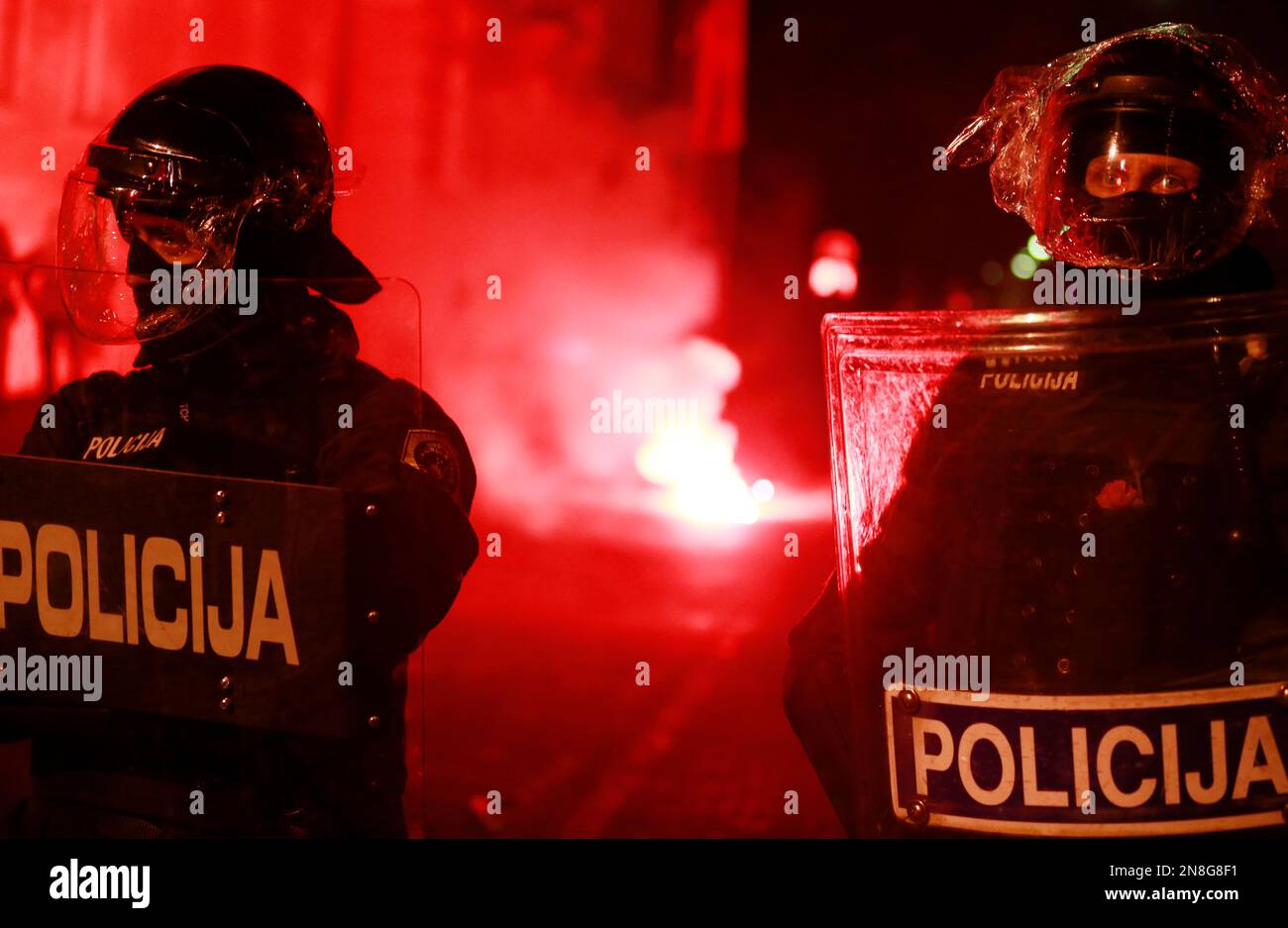 Riot police officers stand guard outside the city hall during a protest ...