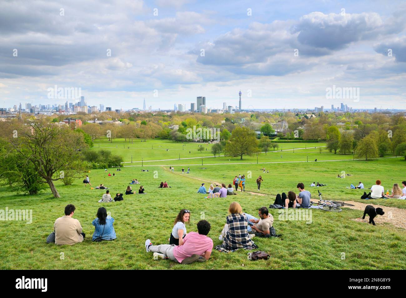 People relaxing on the grassy slopes of Primrose Hill park with ...