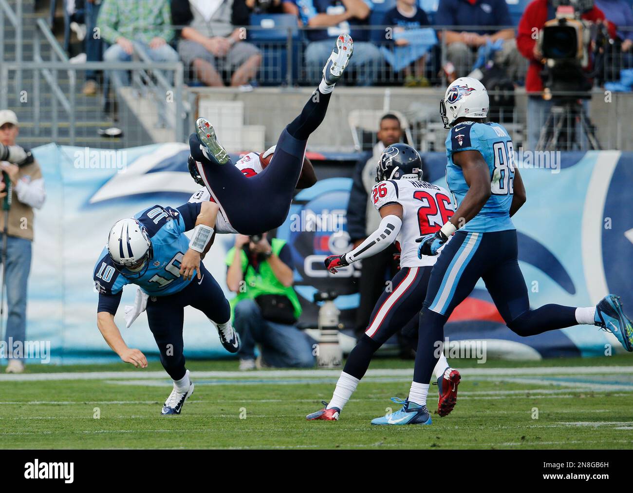 Tennessee Titans quarterback Jake Locker (10) tackles Houston Texans ...
