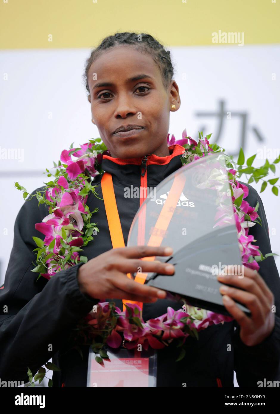 Tadese Feyse Boru of Ethiopia holds her champion trophy during the ...