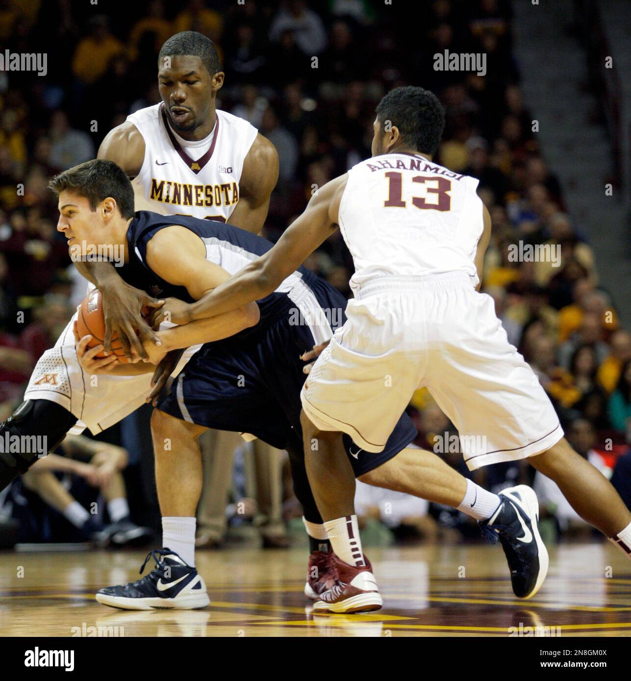 North Florida's Ray Rodriguez, center, is tied up by Minnesota forward ...