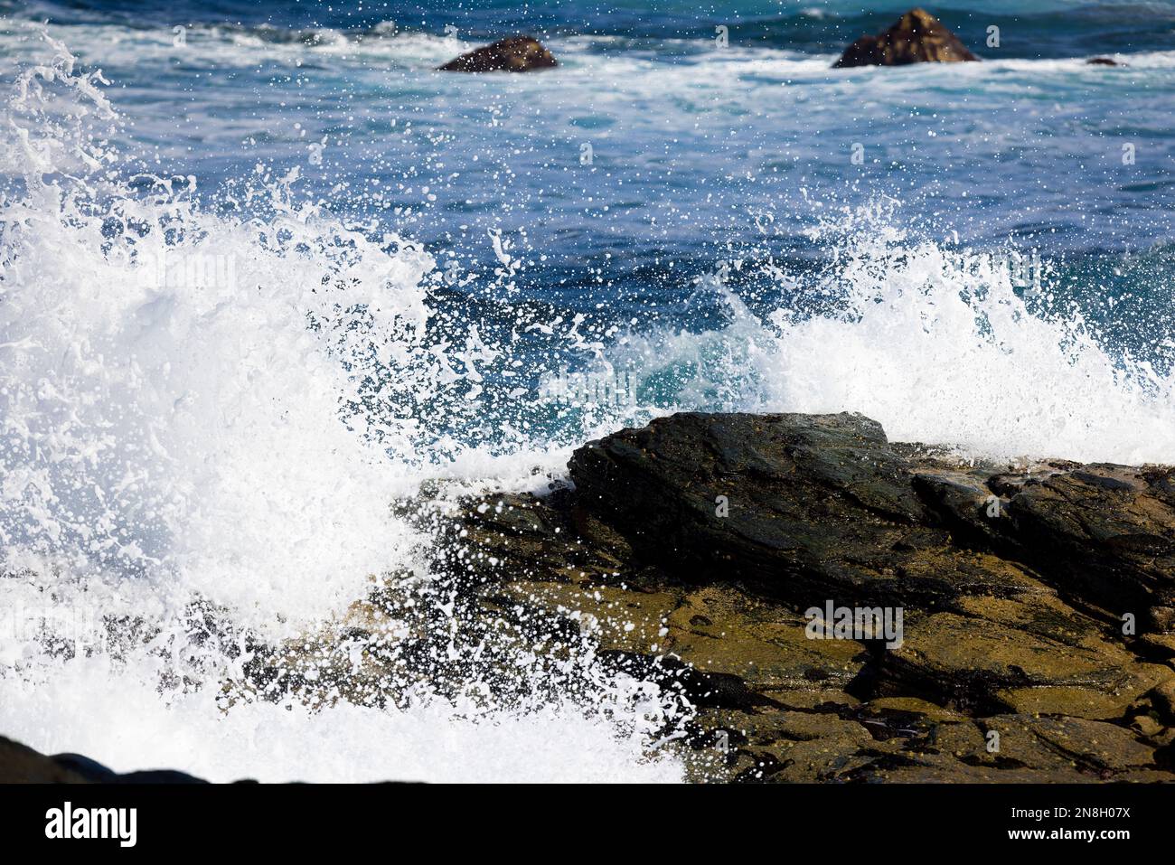Nature's Fury: The ocean's waves hitting rocks on the shore at daylight ...
