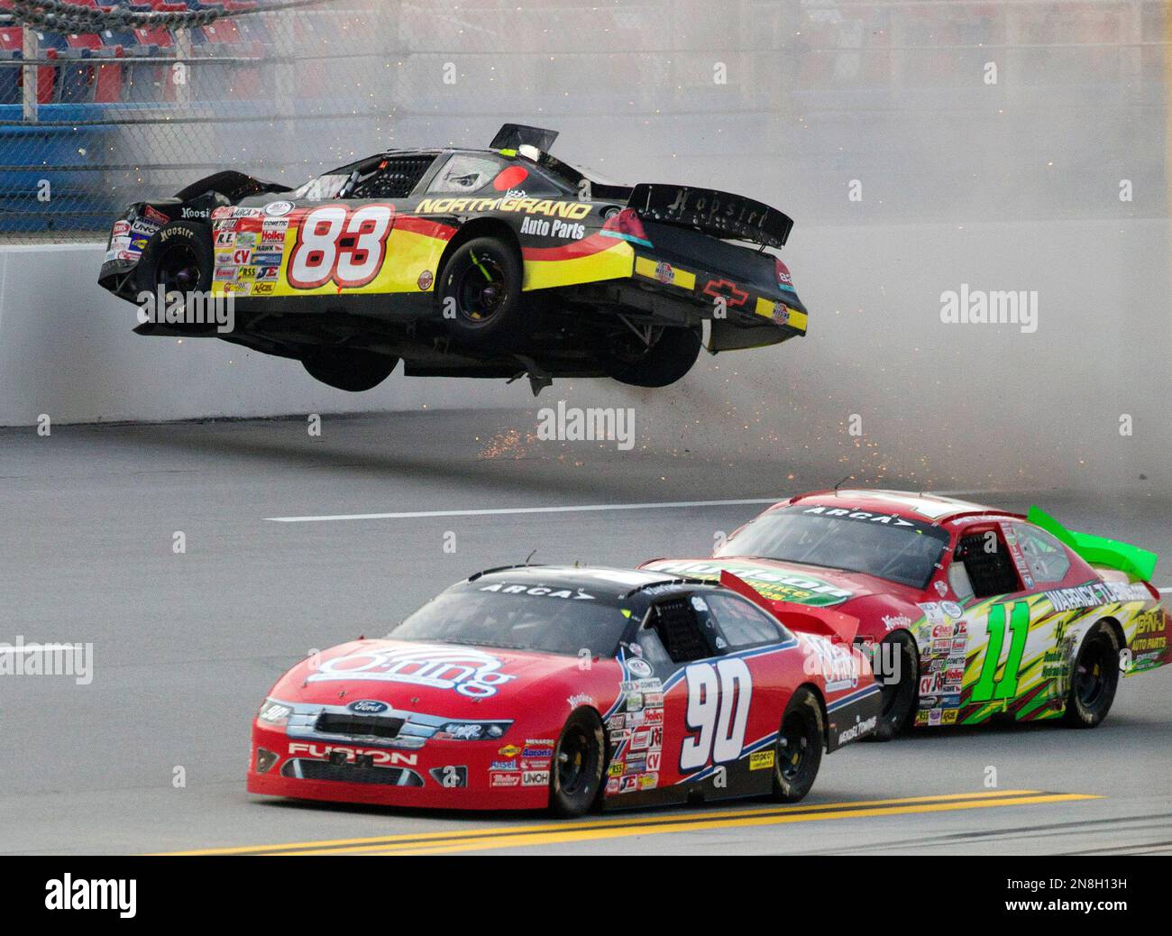 Zach Ralston (90) and Brett Hudson (11) drive past the flipping car of ...