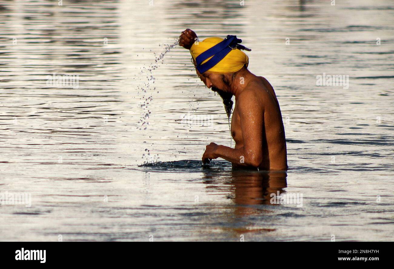 An Indian Sikh devotee takes a holy bath in the sacred pond of the ...