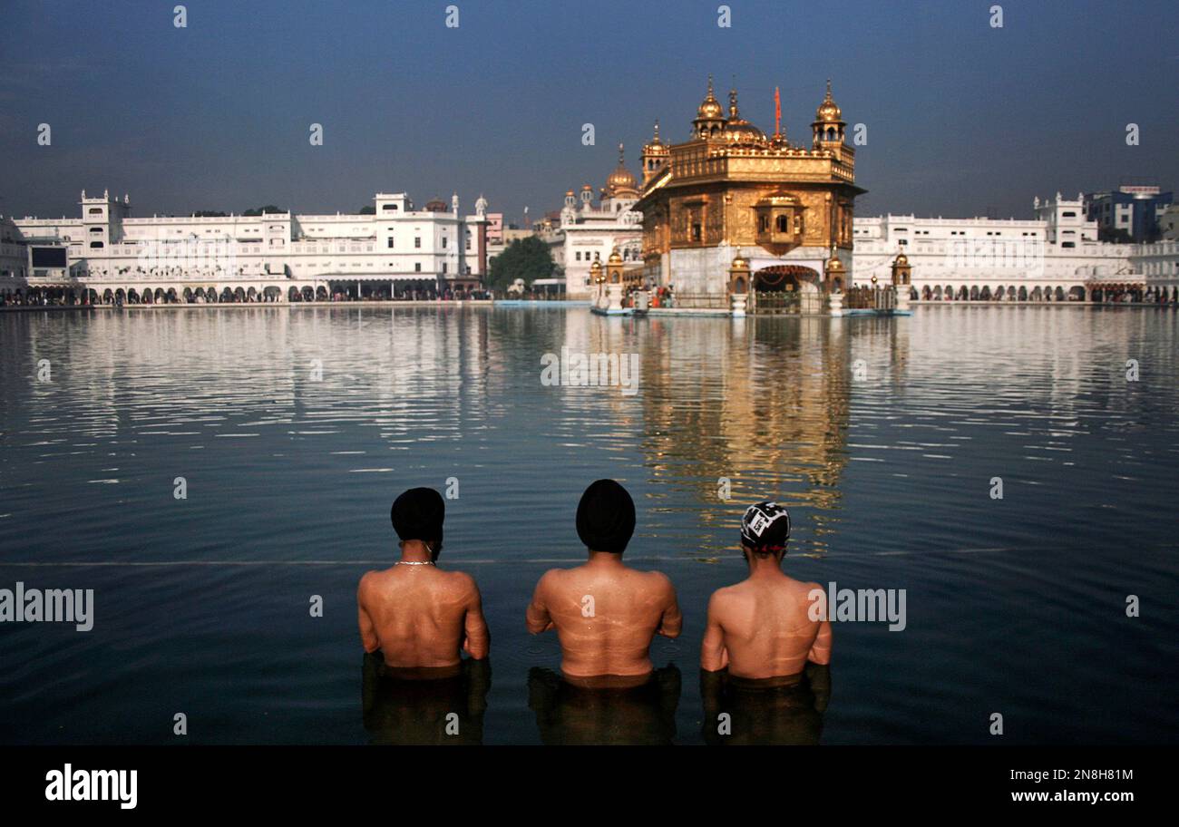 Indian Sikh devotees take a holy bath in the sacred pond of the Golden ...