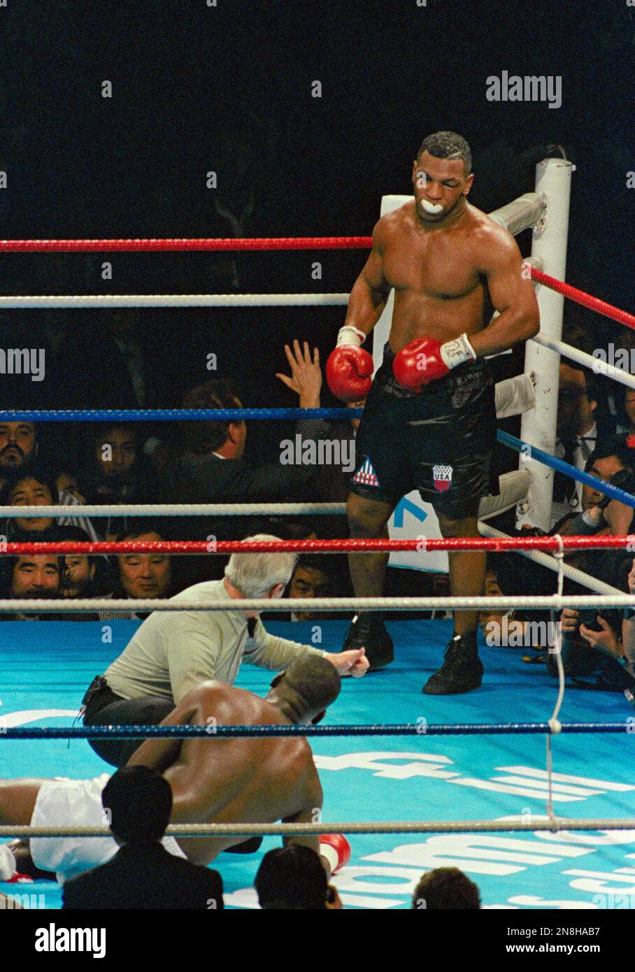 Champion Mike Tyson stands in a neutral corner as referee Octavio Meyon ...