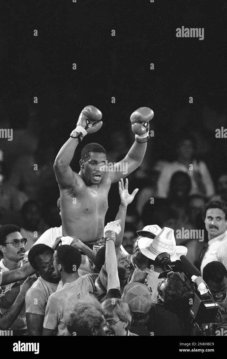 Challenger Tim Witherspoon raises his arms to the crowd in Las Vegas ...