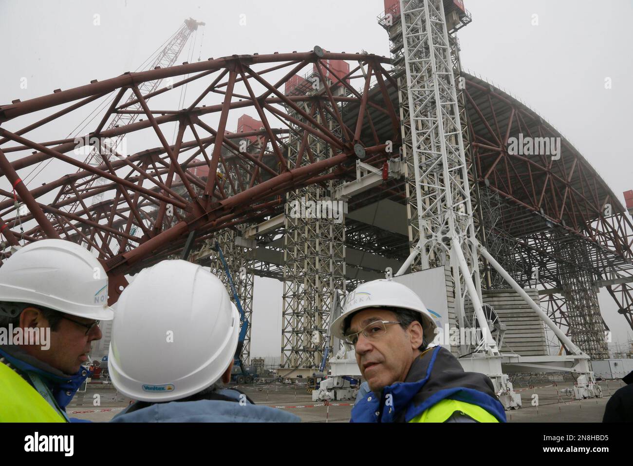 Construction workers assist in the assembly of a gigantic steel-arch to ...