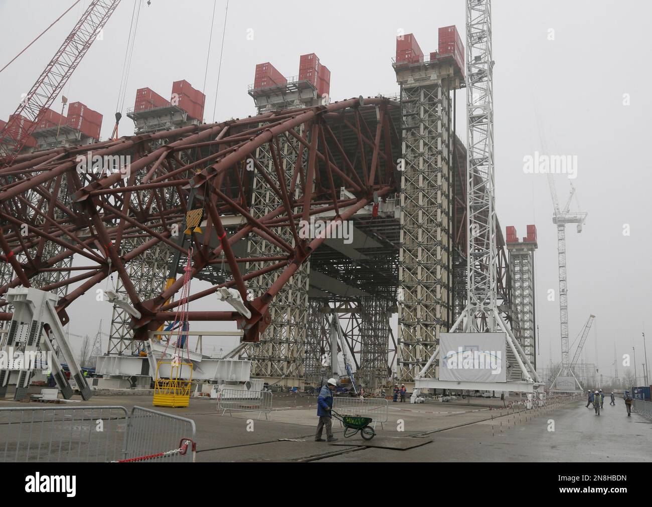 Construction workers assist in the assembly of a gigantic steel-arch to ...