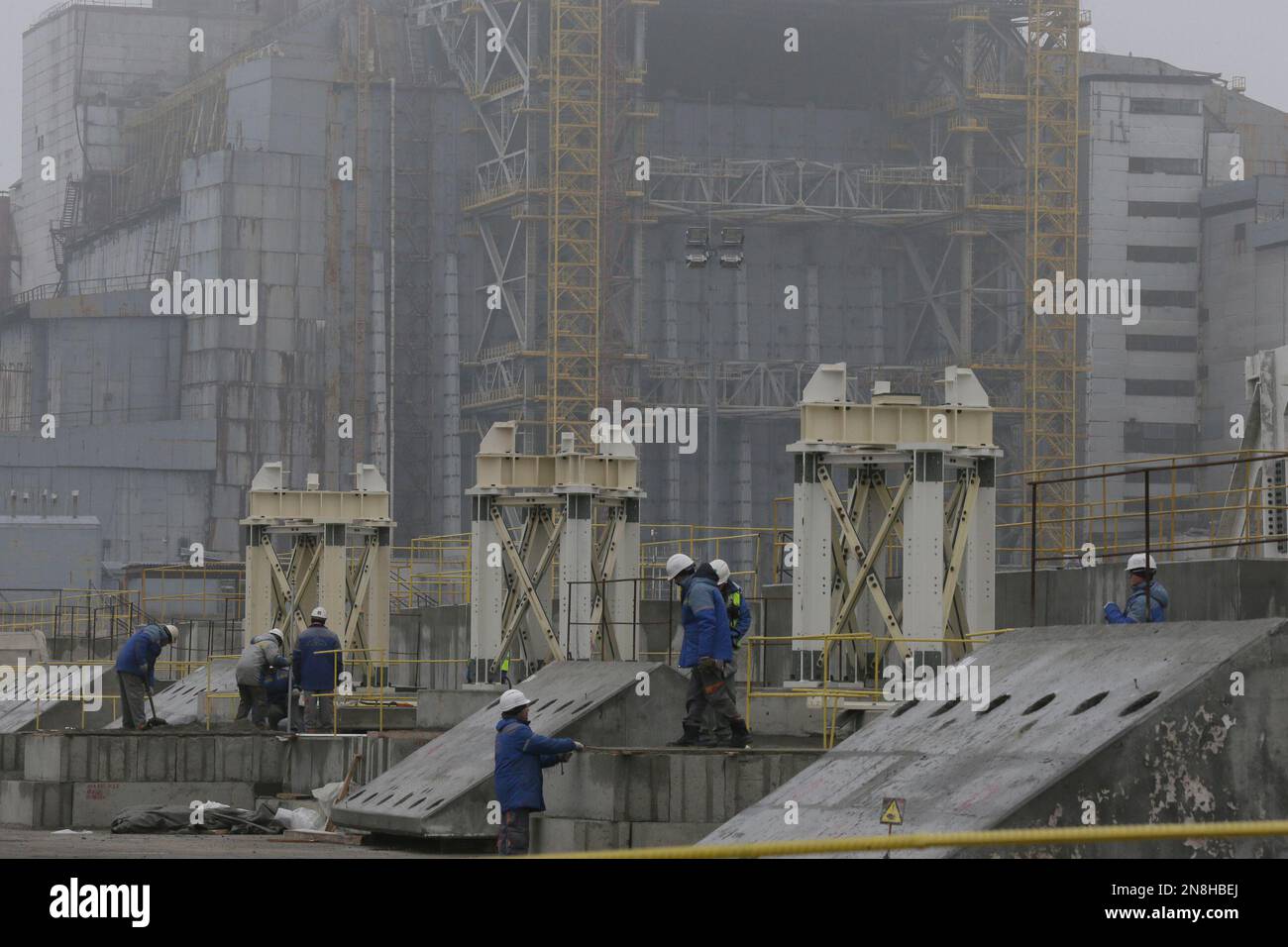 Construction workers assist in the assembly of a gigantic steel-arch to ...