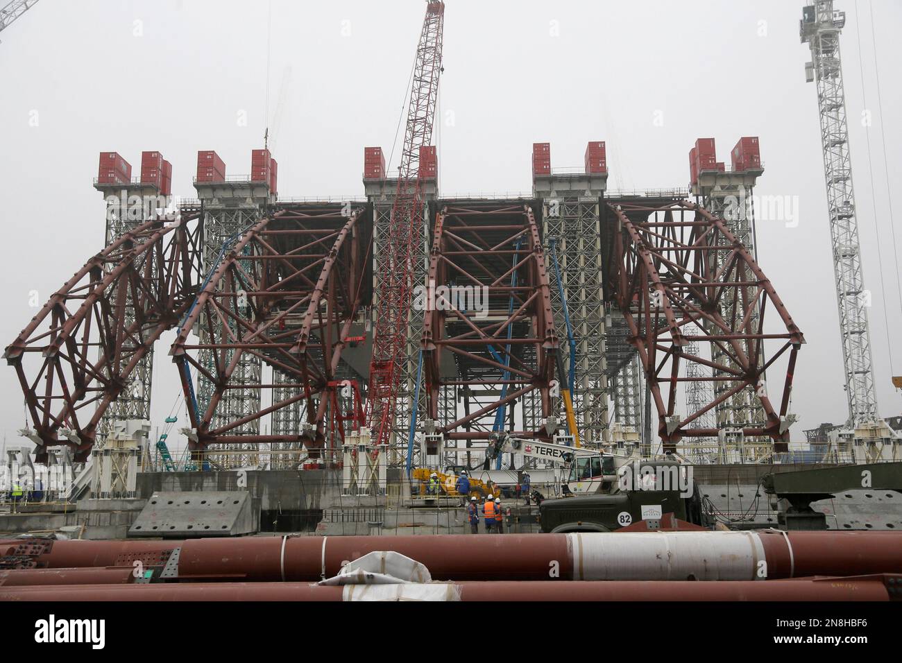 Construction workers assist in the assembly of a gigantic steel-arch to ...