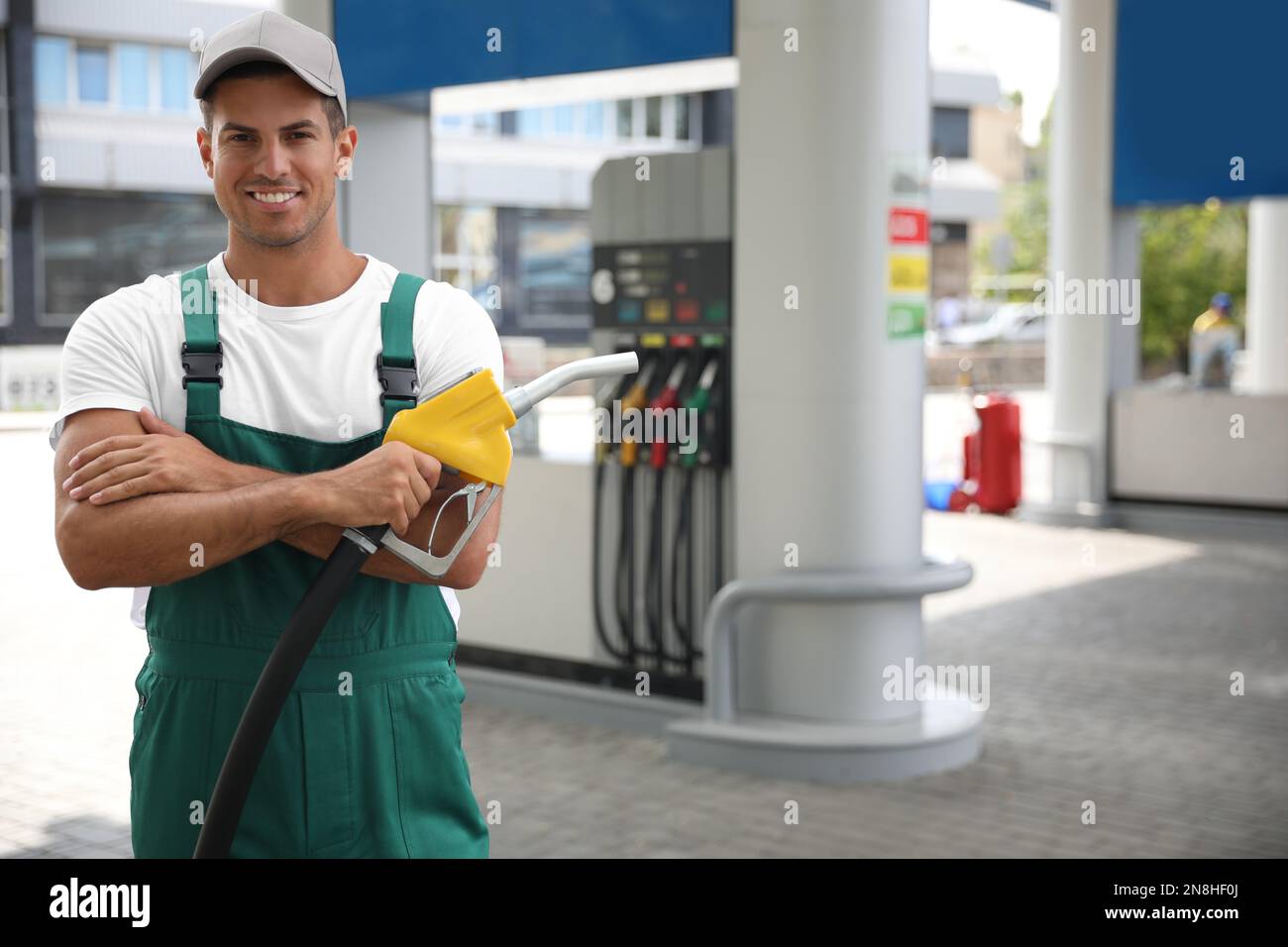 Worker with fuel pump nozzle at modern gas station Stock Photo - Alamy
