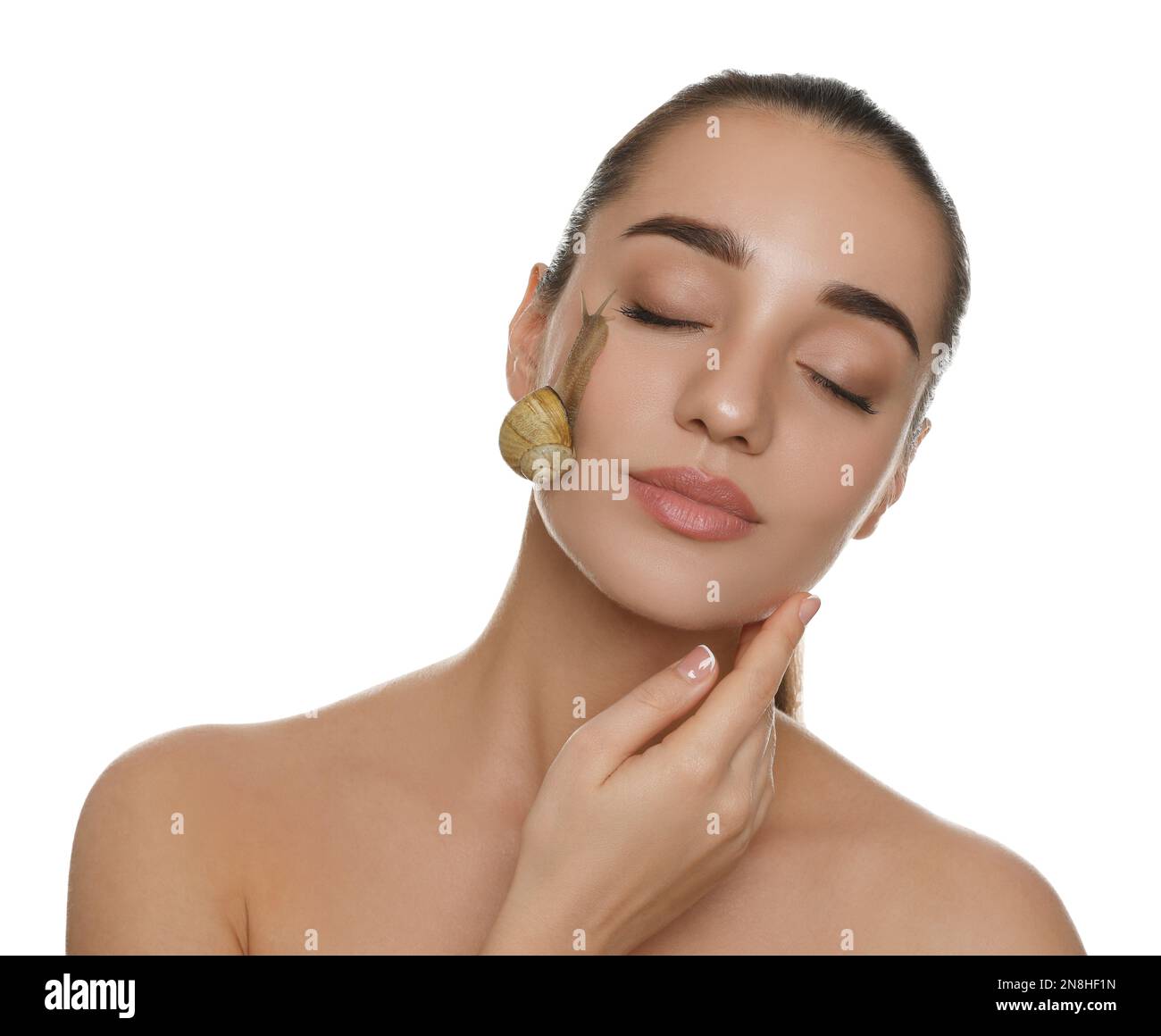 Beautiful young woman with snail on her face against white background ...