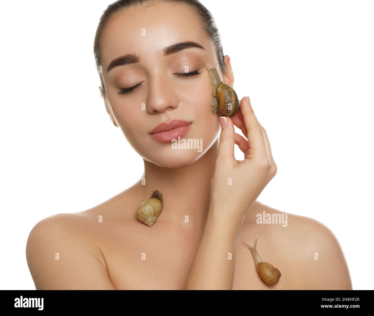 Beautiful young woman with snails on her body against white background ...