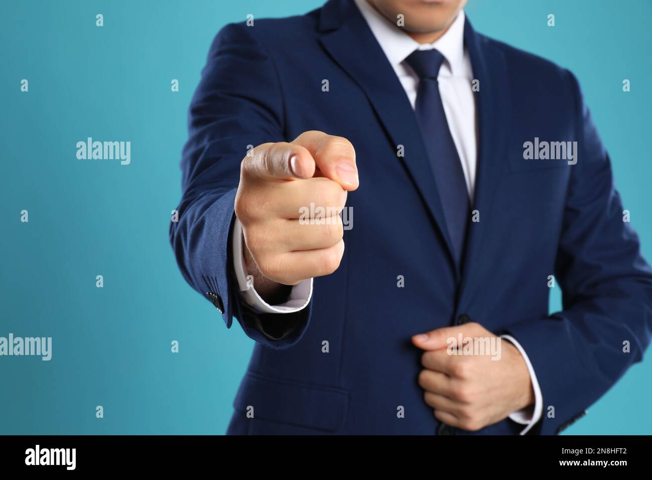 Businessman touching something on light blue background, closeup ...