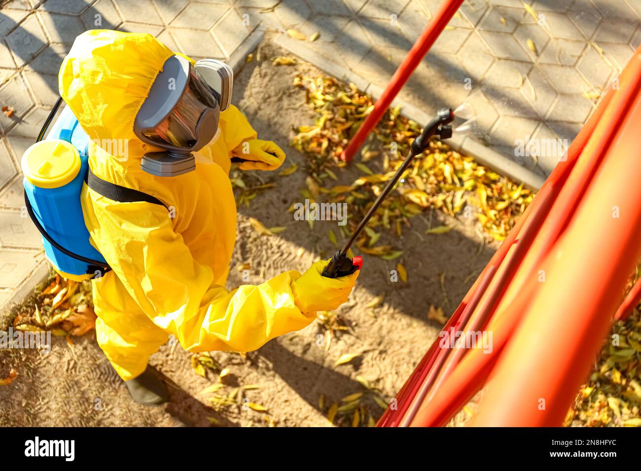 Person in hazmat suit with disinfectant sprayer cleaning children's ...