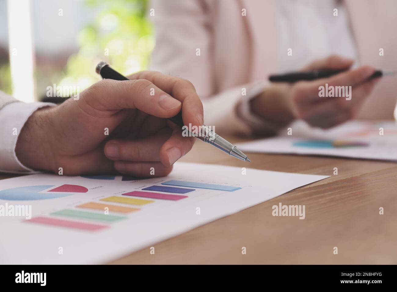 Business people working with charts and graphs at table in office ...