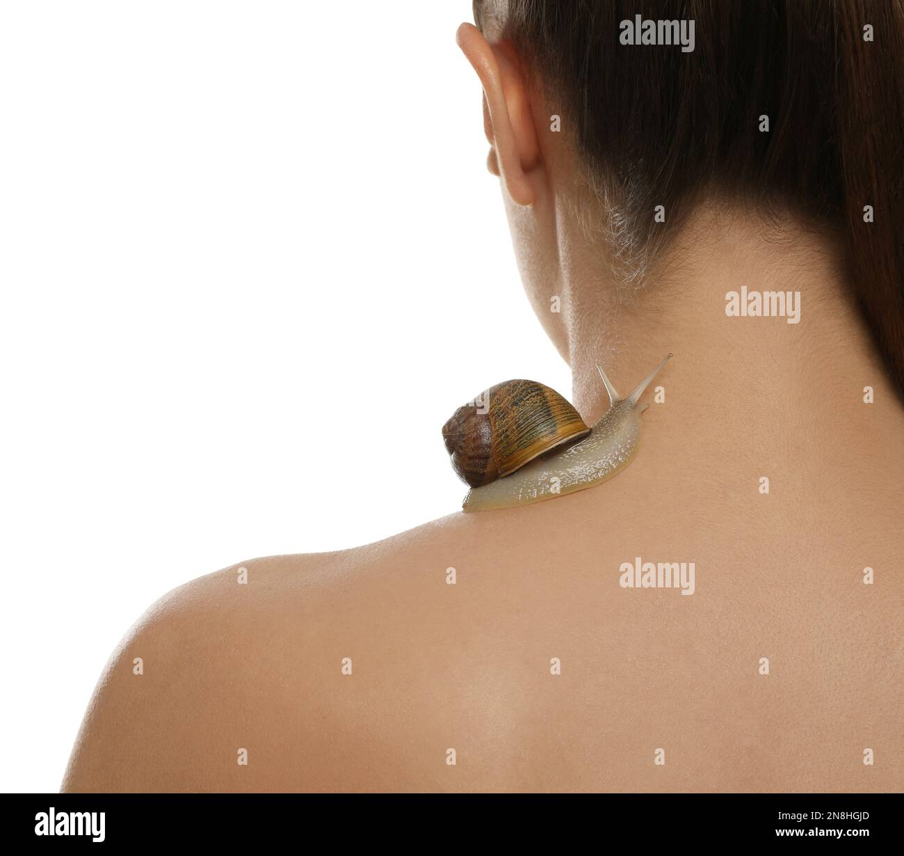 Beautiful young woman with snail on her back against white background ...