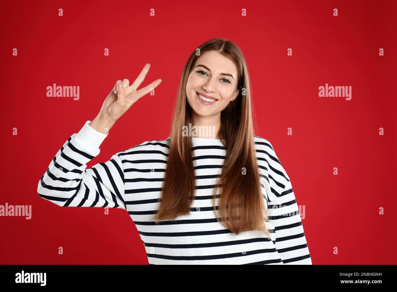 Woman showing number two with her hand on red background Stock Photo ...