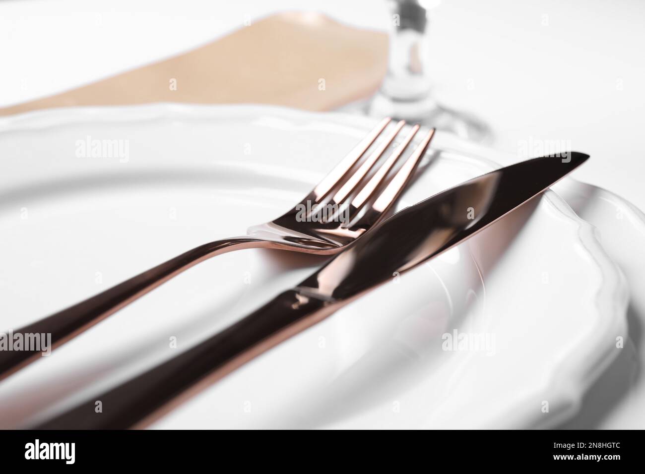 Plates with golden cutlery on table, closeup Stock Photo - Alamy