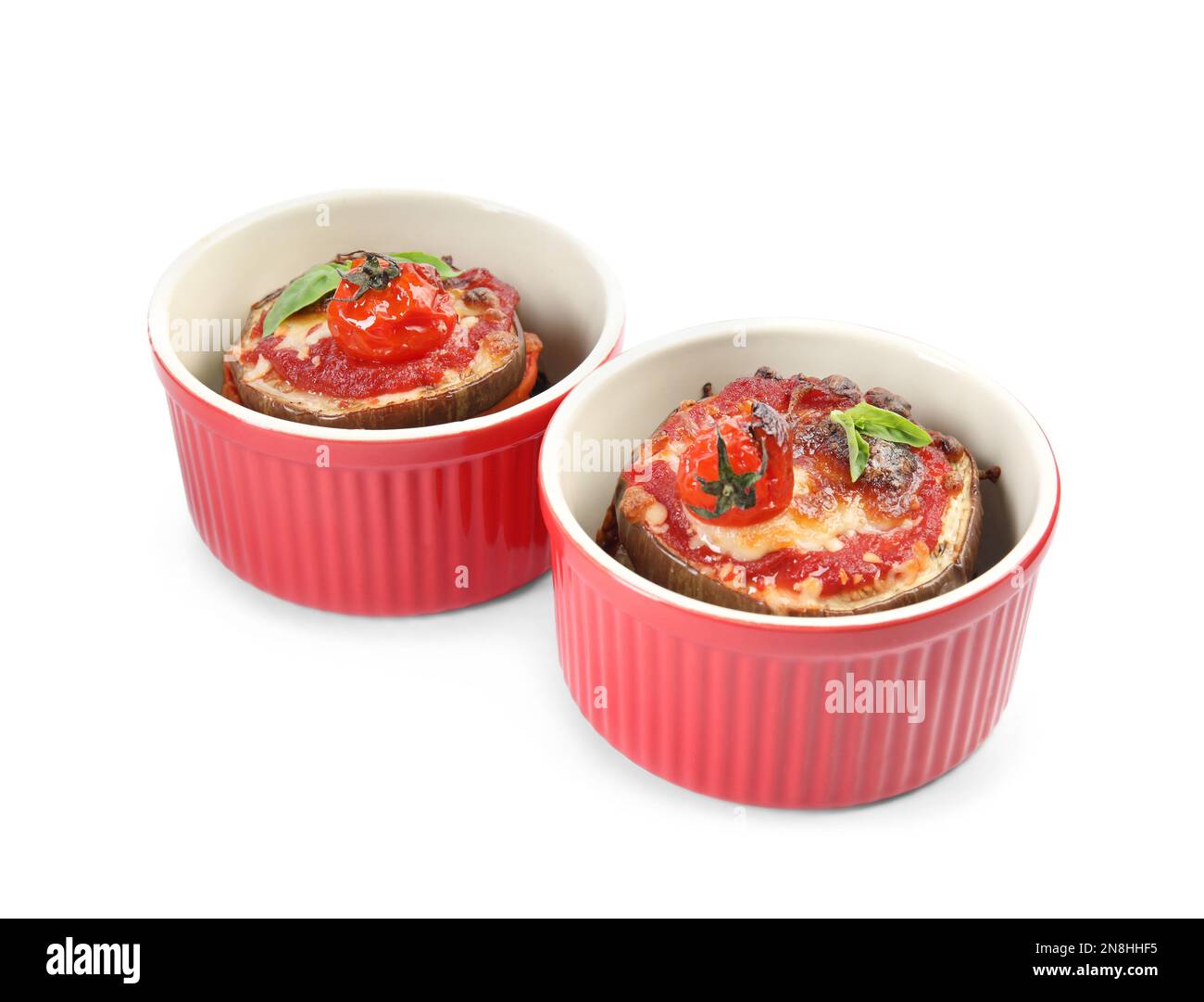 Baked eggplant with tomatoes, cheese and basil in ramekins isolated on ...