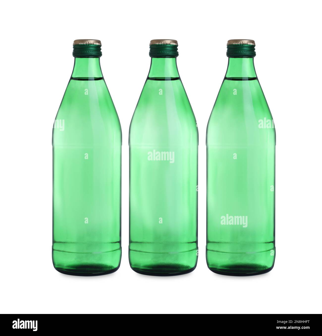 Glass bottles with water on table against white background Stock Photo ...